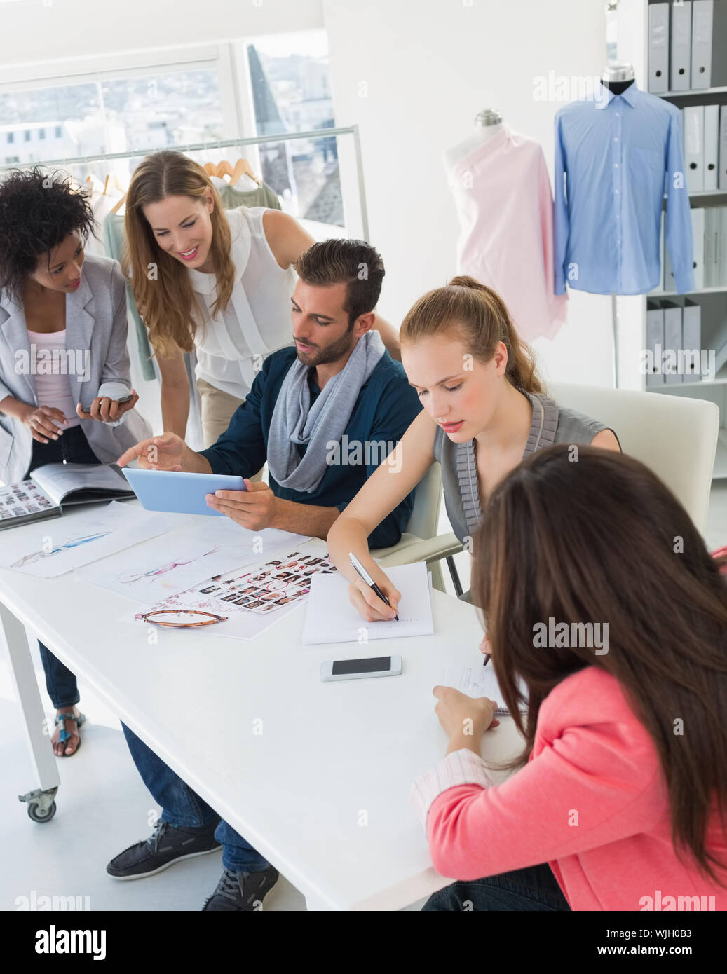 Group of fashion designers discussing designs in a studio Stock Photo ...
