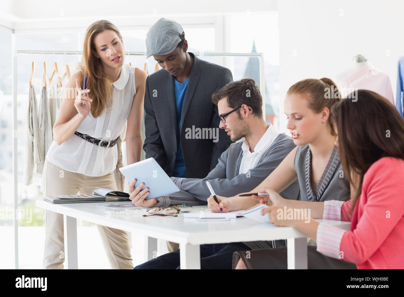 Group of fashion designers discussing designs in a studio Stock Photo ...