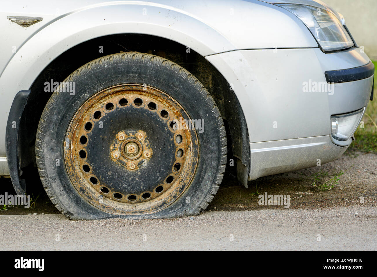 car with flat tire on old rusty rim Stock Photo - Alamy