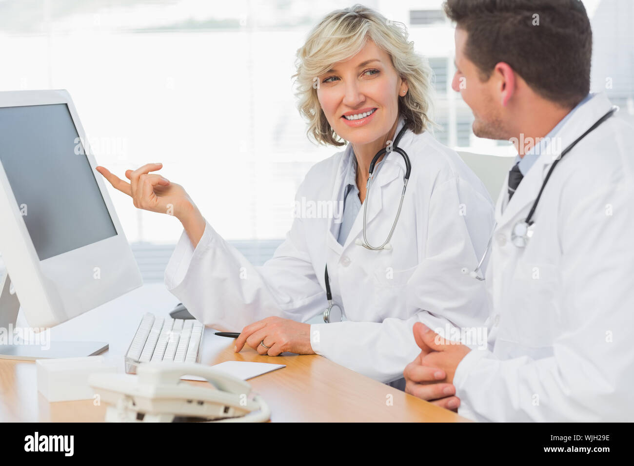 Two concentrated doctors using computer at medical office Stock Photo ...