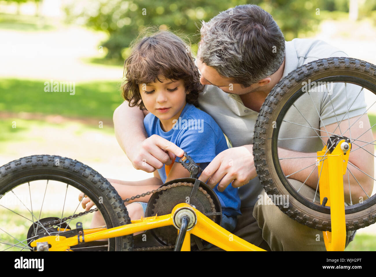 Close-up of father and son fixing bike Stock Photo - Alamy