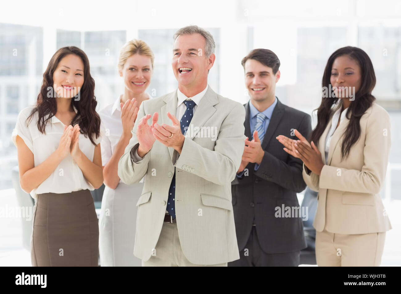 Business team standing and clapping in the office Stock Photo - Alamy