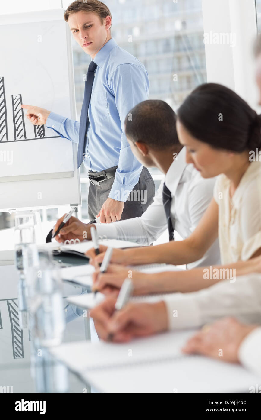 Serious businessman presenting bar chart in meeting in the office Stock ...