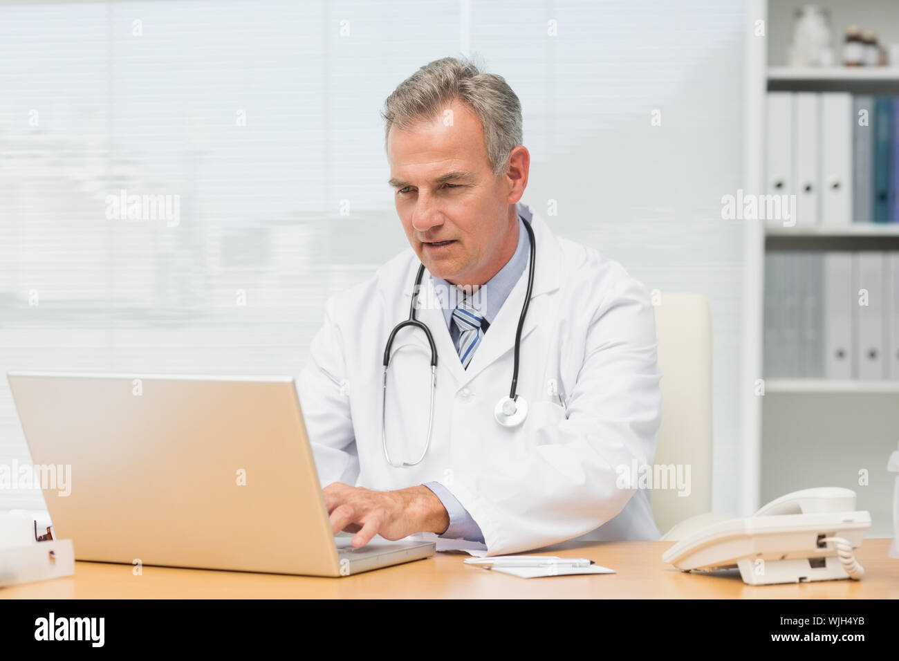 Male doctor sitting desk typing hi-res stock photography and images - Alamy
