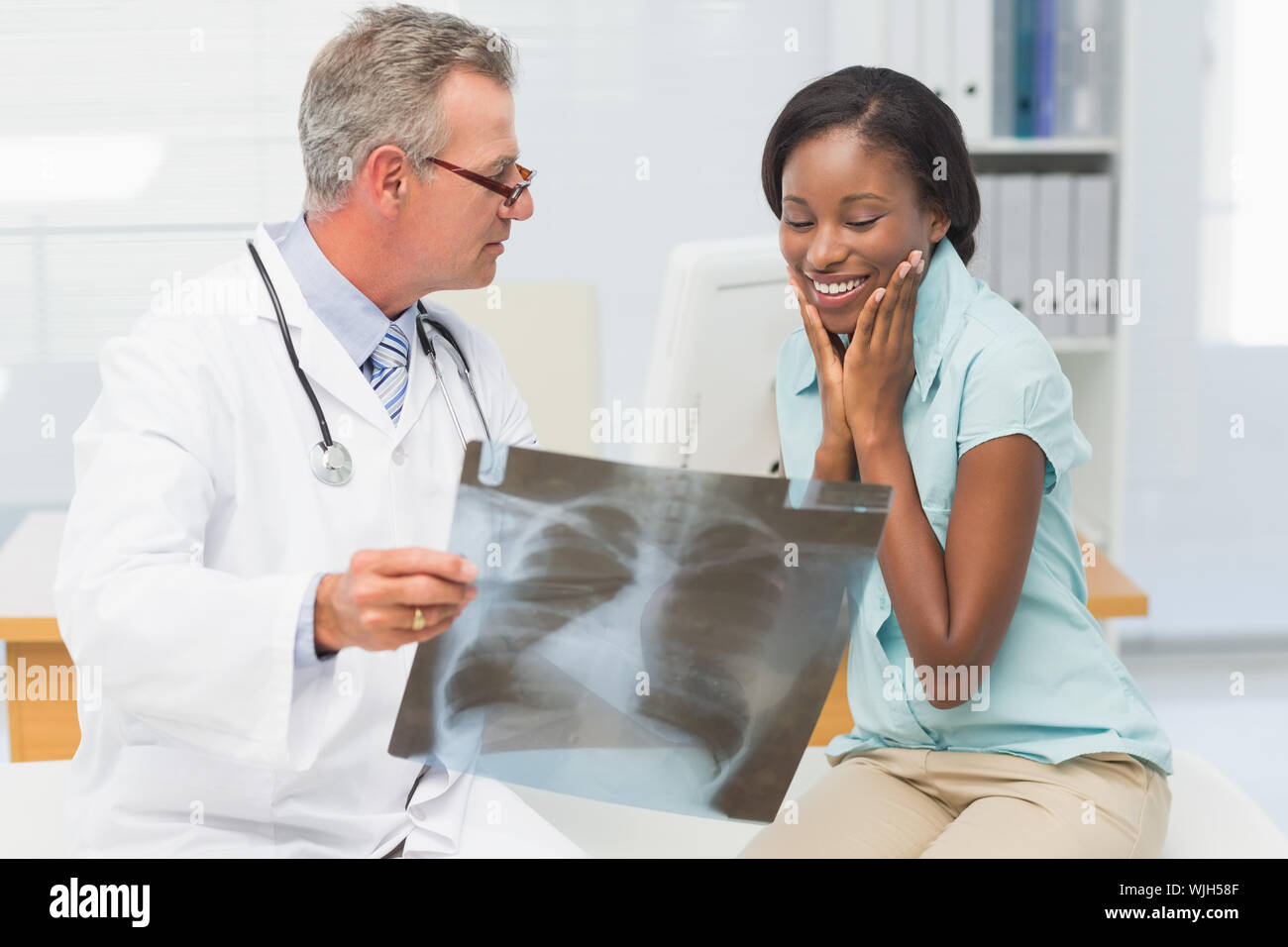 Doctor showing young patient her positive chest xray in his office at ...