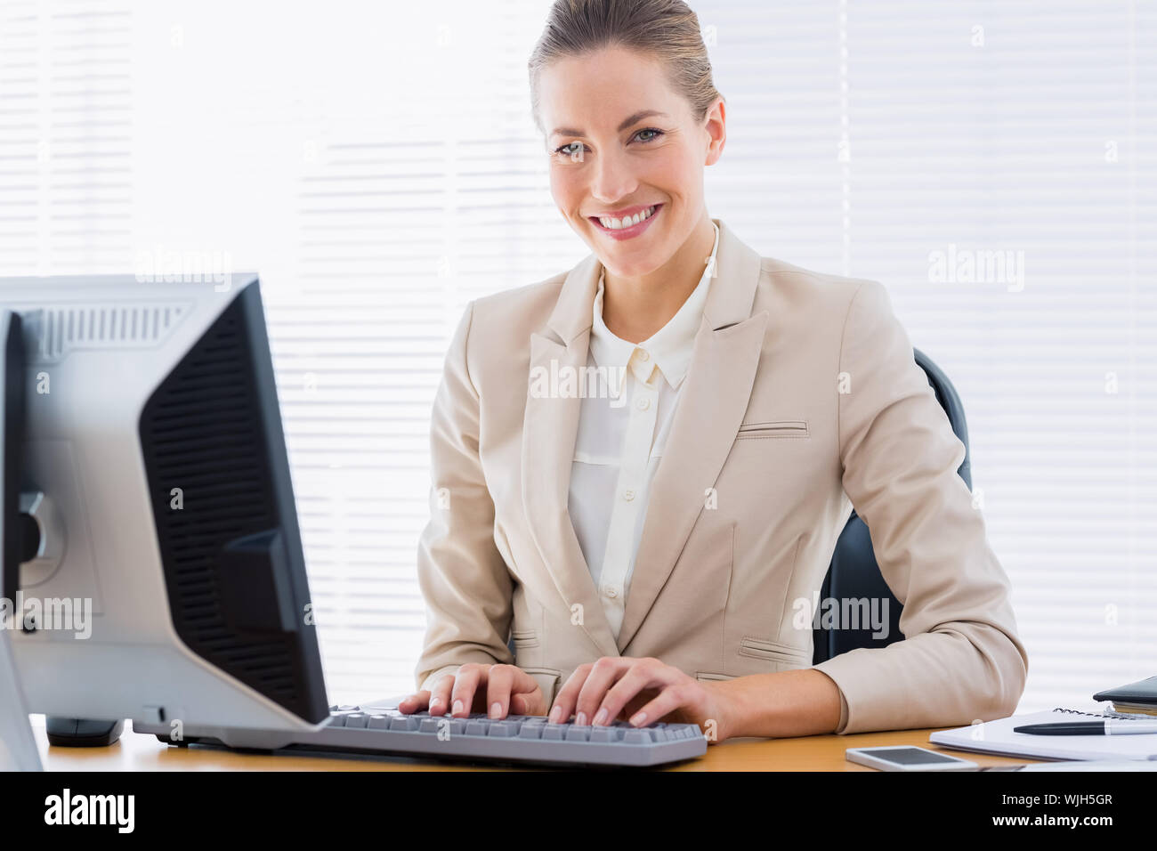 Portrait of a smartly dressed young businesswoman using computer at ...