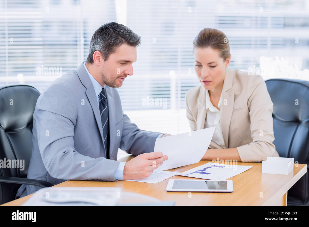 Smartly dressed young man and woman in a business meeting at office ...
