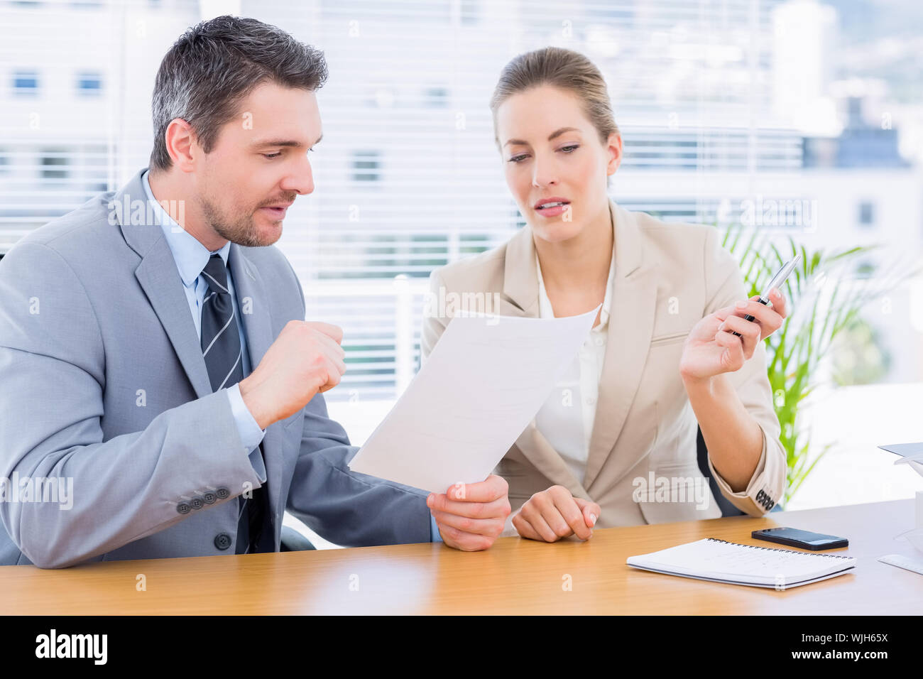 Smartly dressed young man and woman in a business meeting at office ...