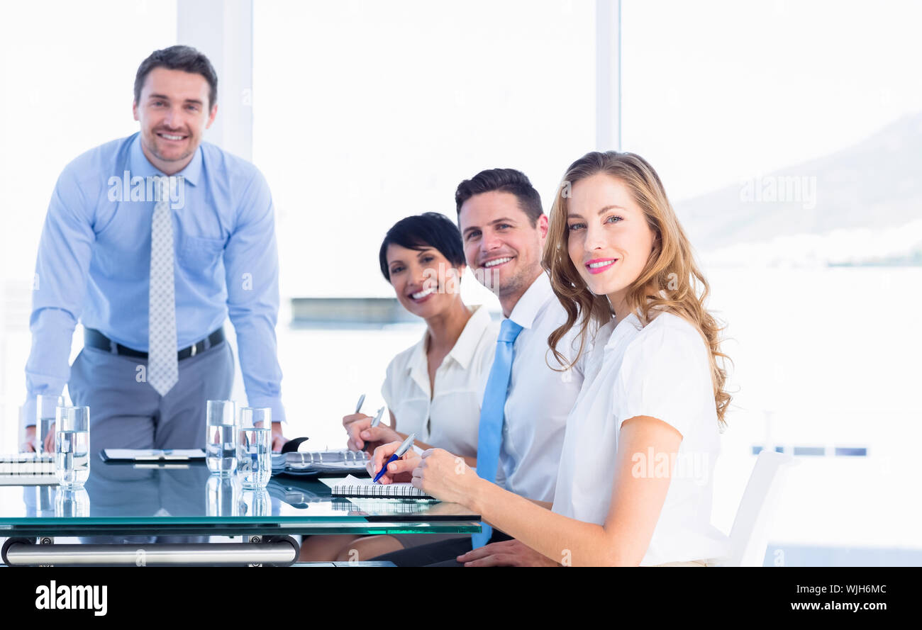 Smartly dressed young executives around conference table in office ...
