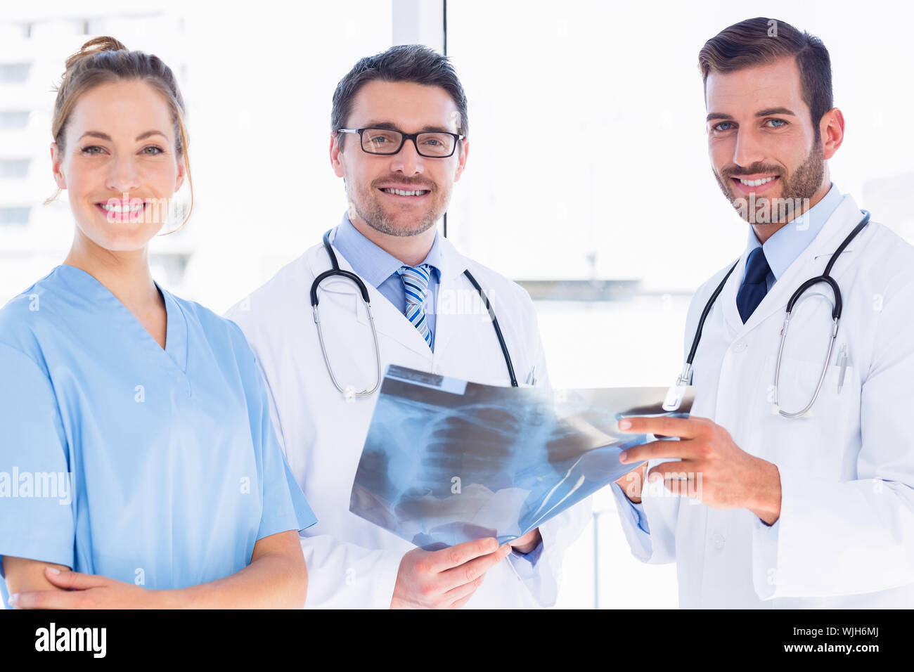 Portrait of two male doctors and surgeon with x-ray report at the ...