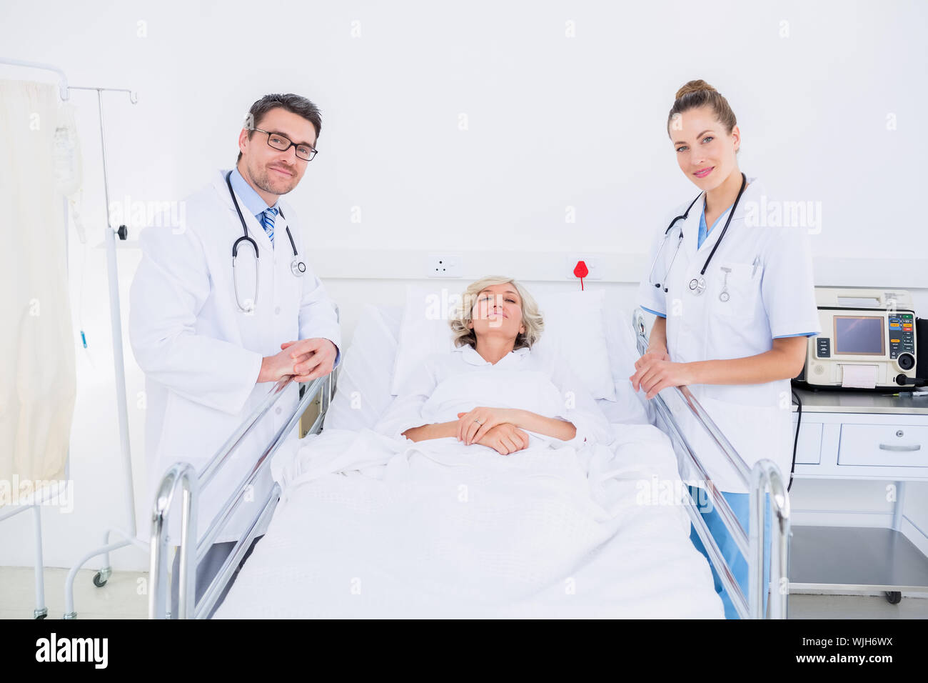 Portrait of two doctors visiting a female patient in the hospital Stock ...