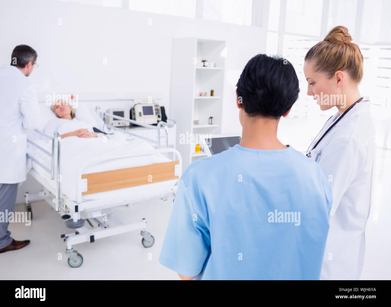 Doctors visiting female patient hi-res stock photography and images - Alamy