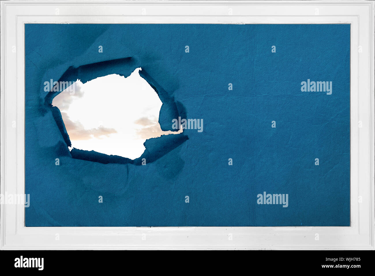 Rip on wall showing bright sky Stock Photo - Alamy