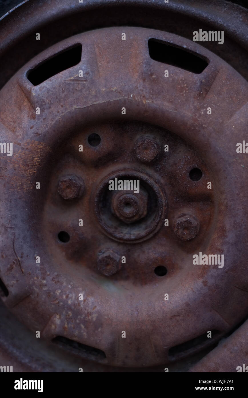 Rusty old car wheel (automobile) rusting in a scrapyard. Car auto parts ...