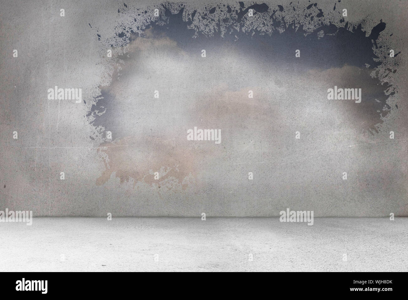 Splash on wall revealing bright sky Stock Photo - Alamy
