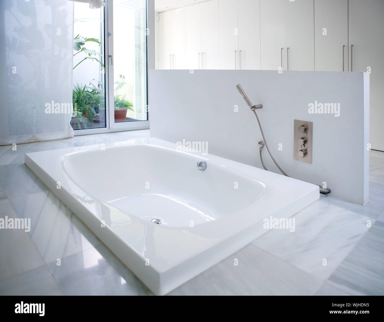 Modern white house bathroom bathtub with marble floor and courtyard ...