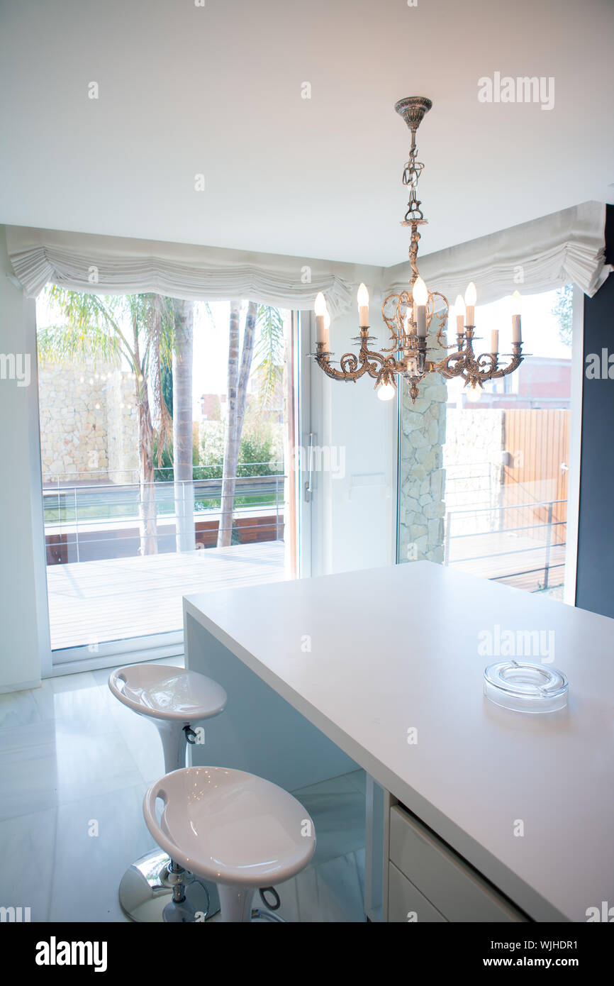 Modern white kitchen table with vintage chandelier and stools Stock ...