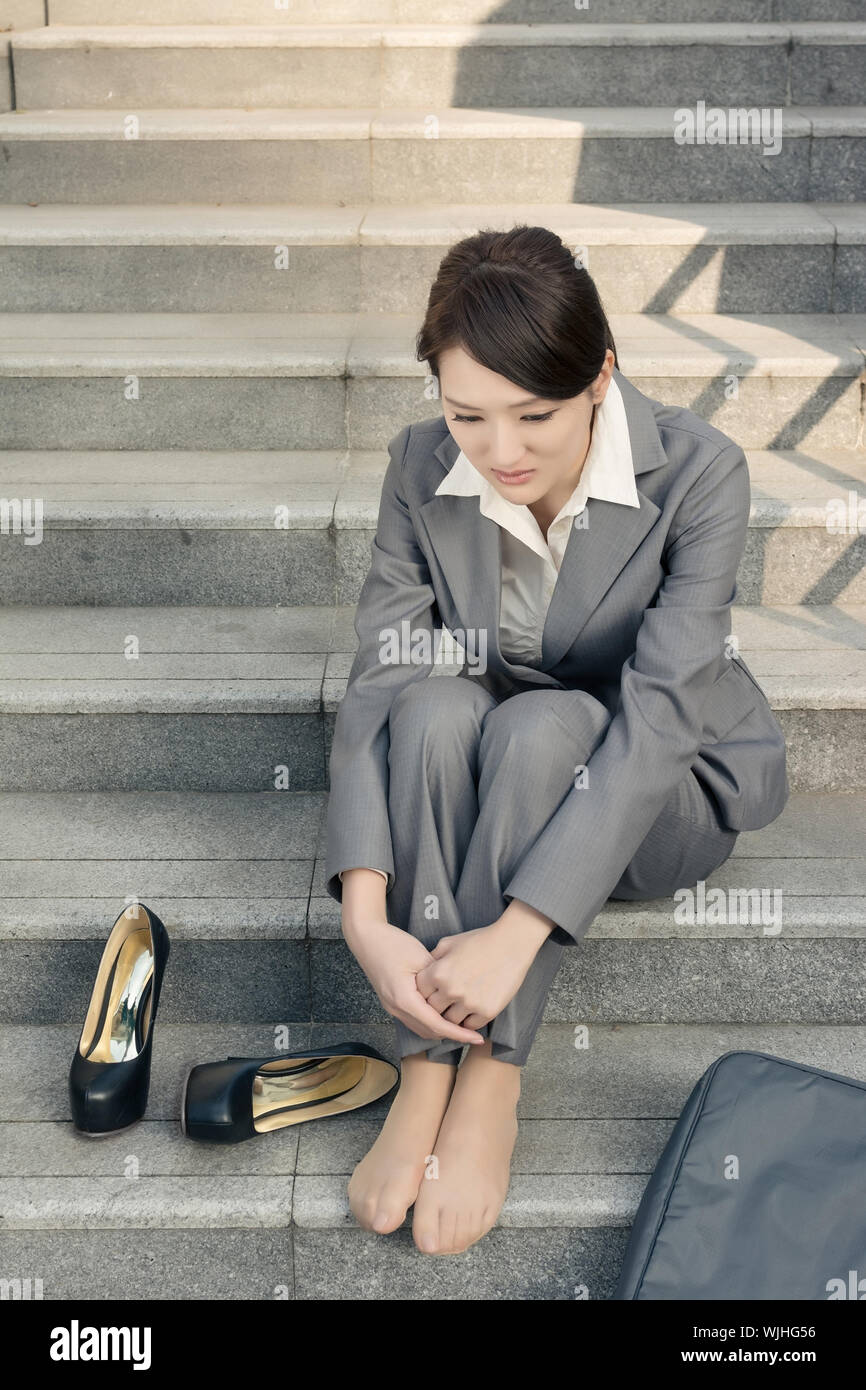 Sad business woman feel helpless and sit on stairs in modern city Stock ...