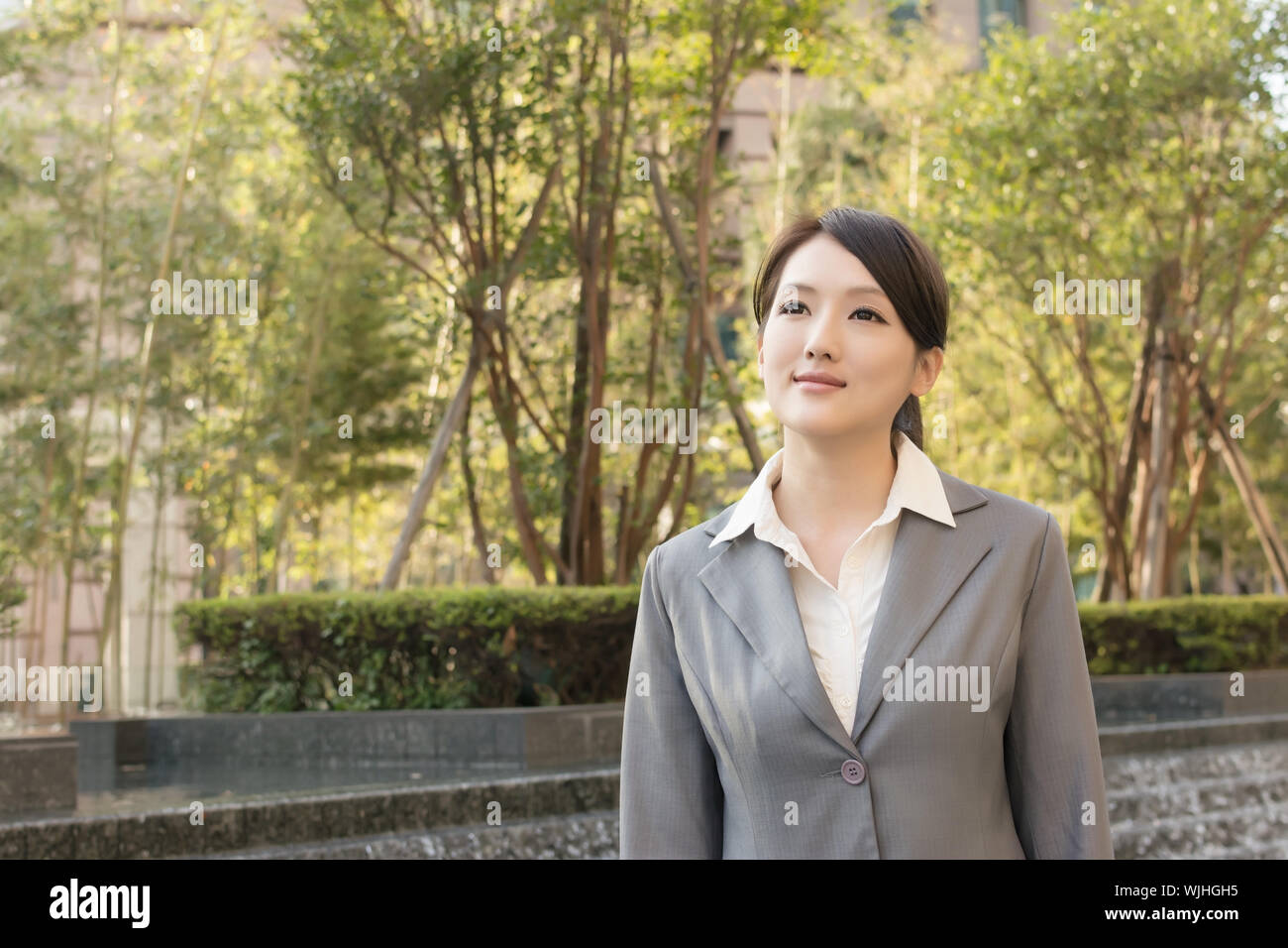 Asian business woman thinking in the city Stock Photo - Alamy