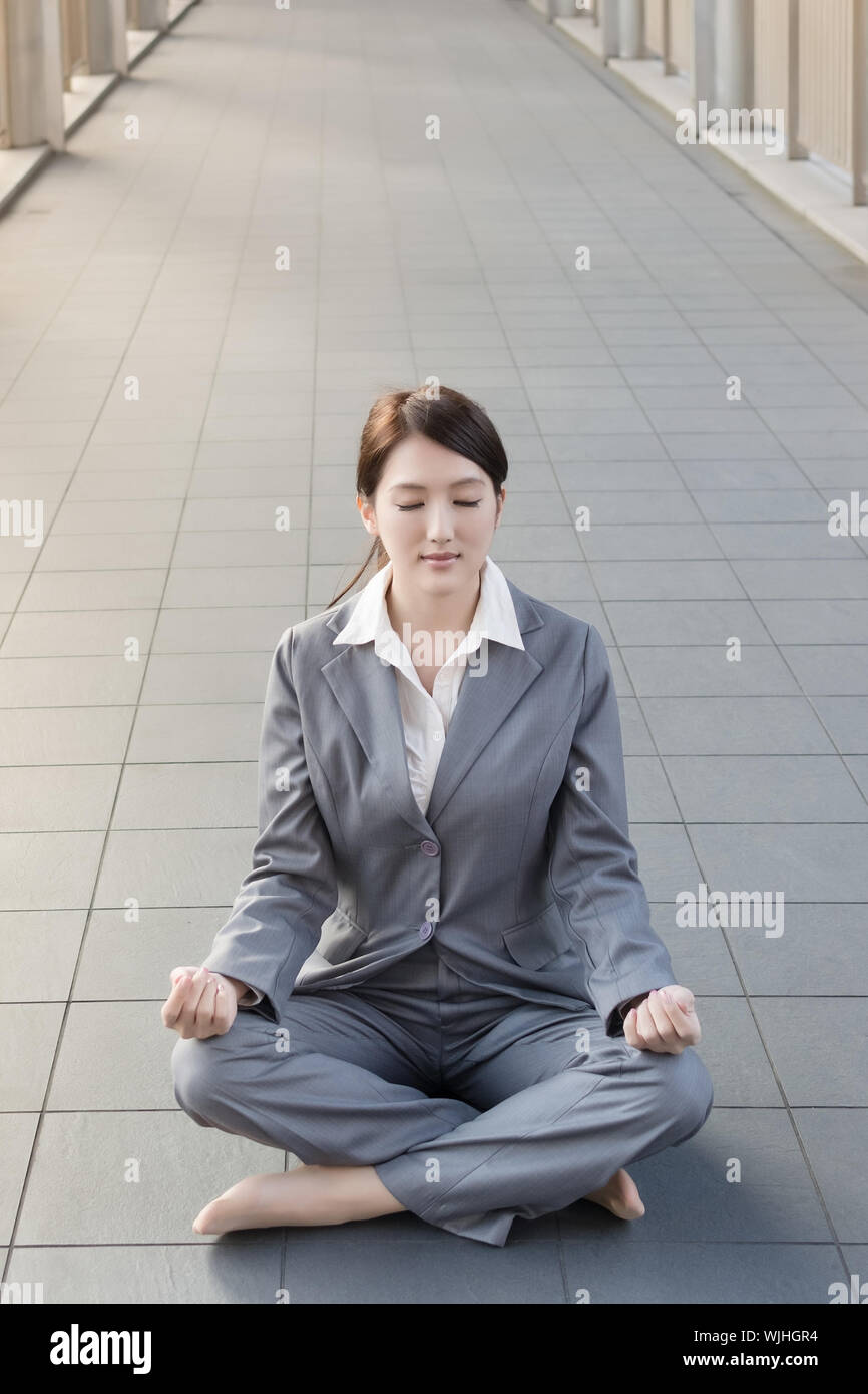 Tranquility or contemplative concept with business woman sit on ground ...