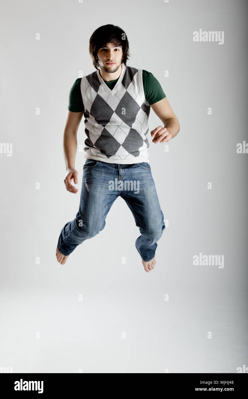 Young modern man jumping over a white background Stock Photo - Alamy