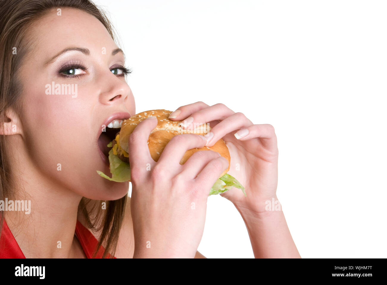 Beautiful woman biting food Stock Photo - Alamy