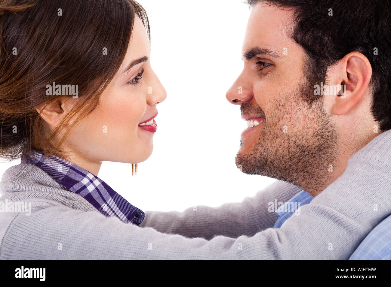 Beautiful couple smiling and facing each other on a isolated white ...
