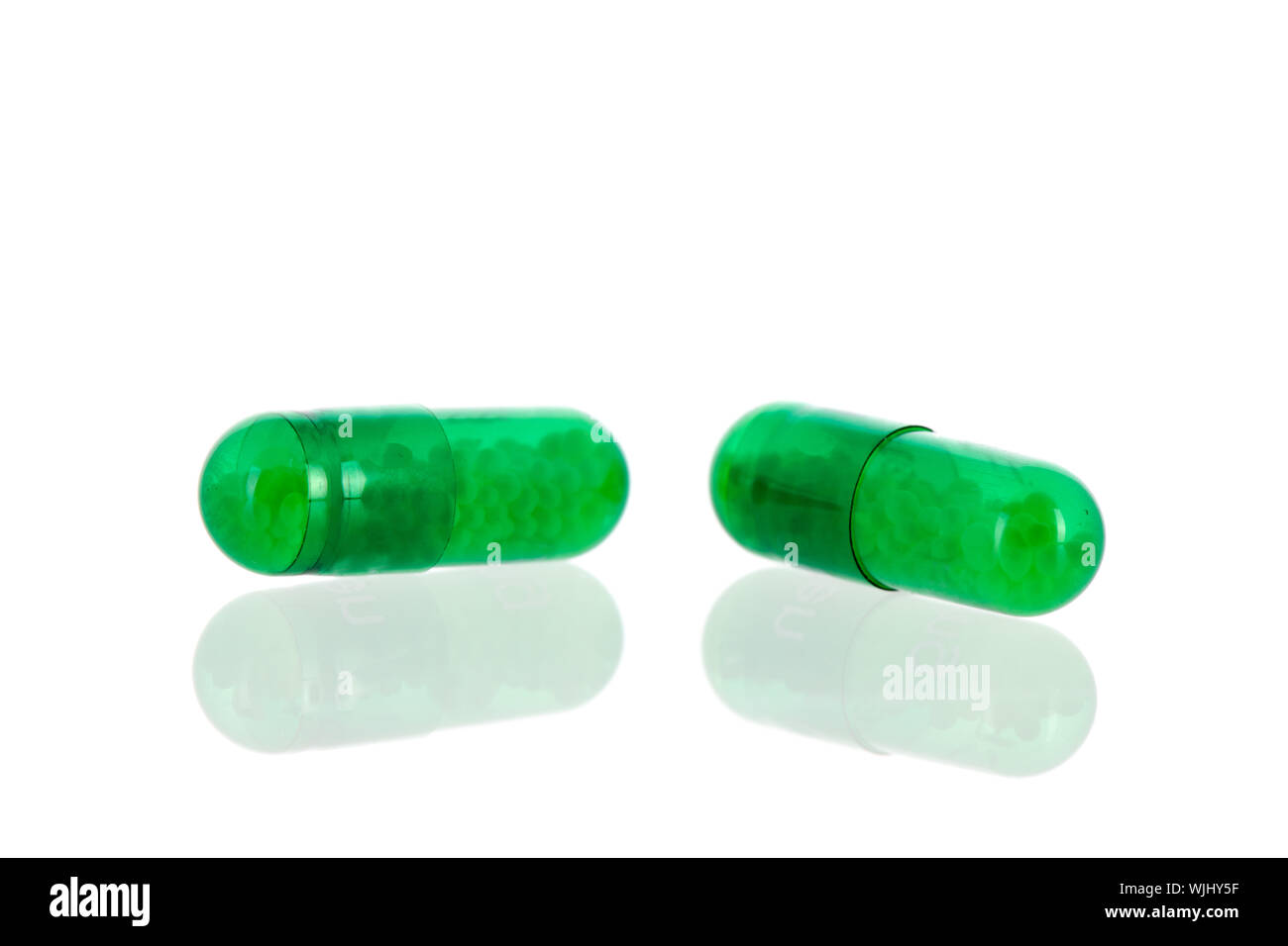 Green medicine in capsules isolated over white background Stock Photo ...