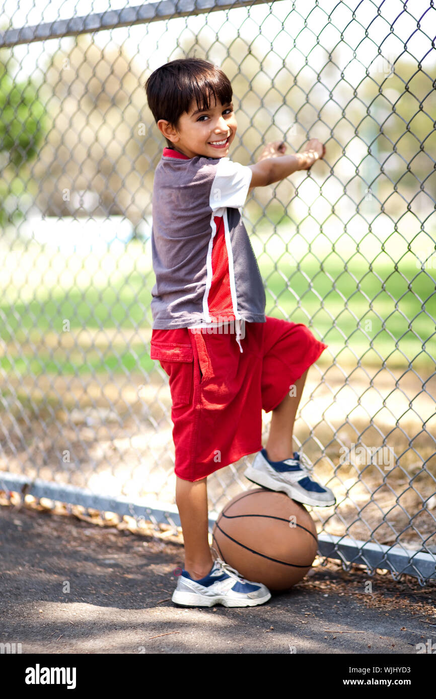 Smart kid posing with basketball as he holds it under his leg Stock ...