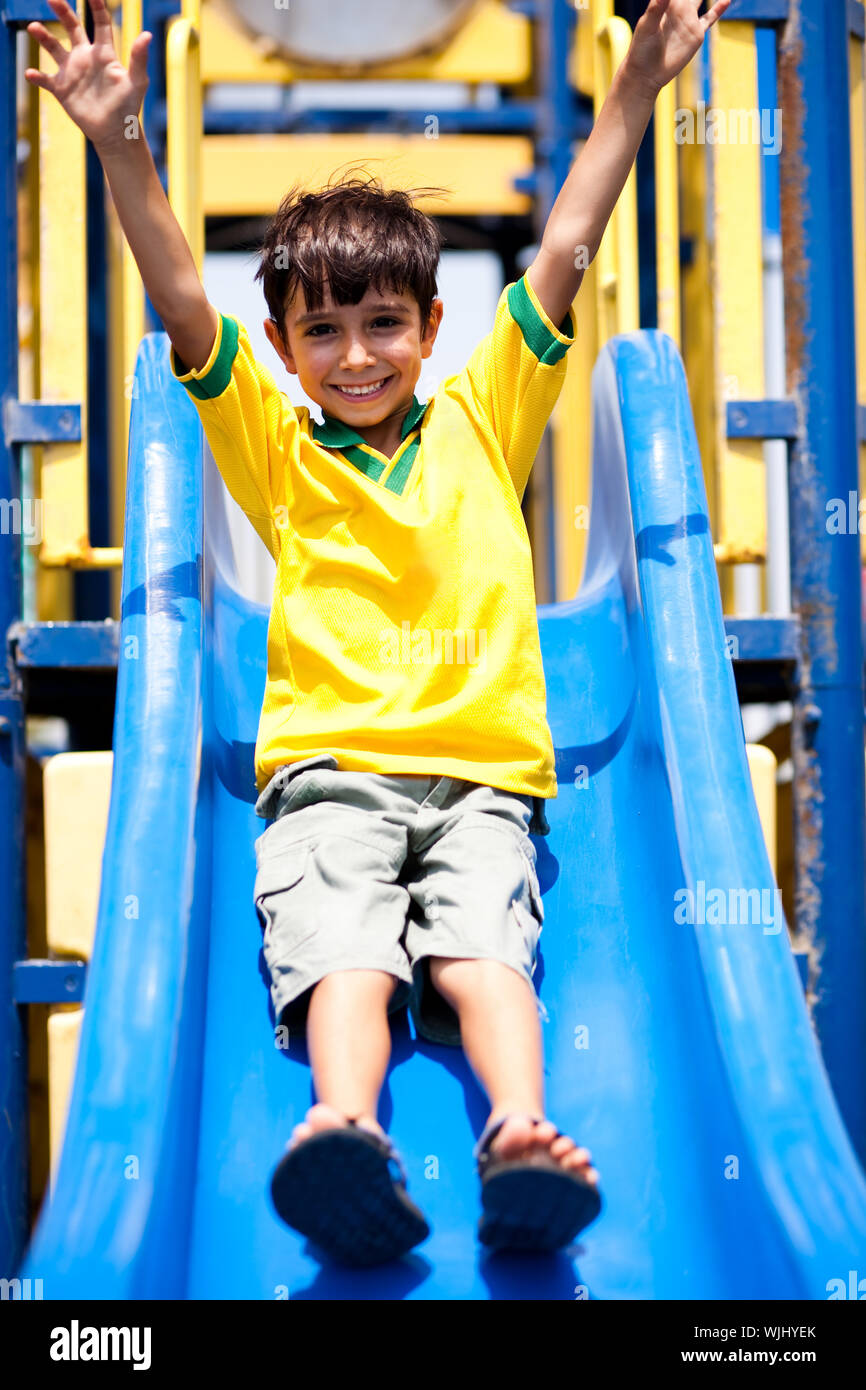 Young smart kid sliding down the swing Stock Photo - Alamy