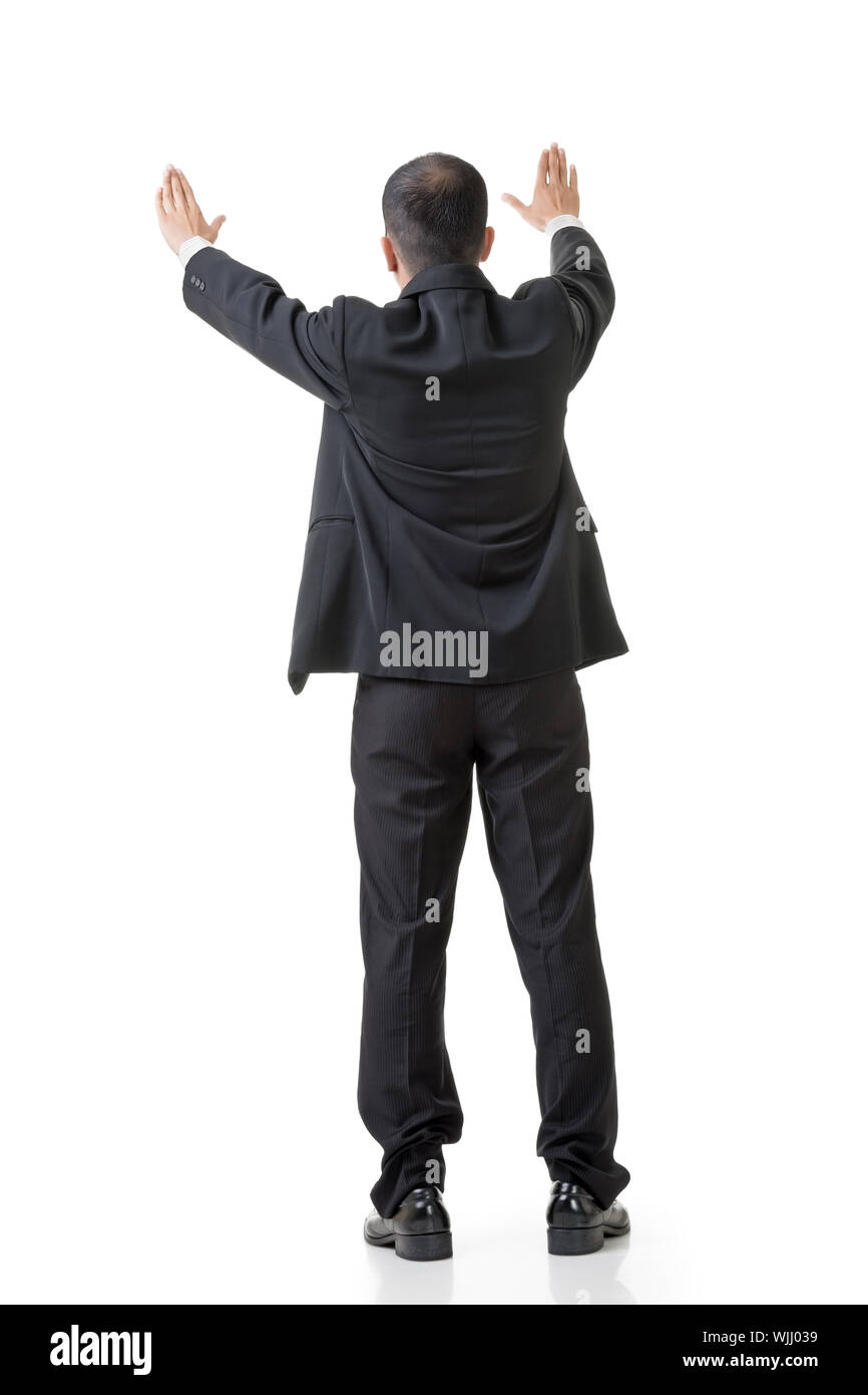 Rear view of Asian business man raising hand to put something over his ...