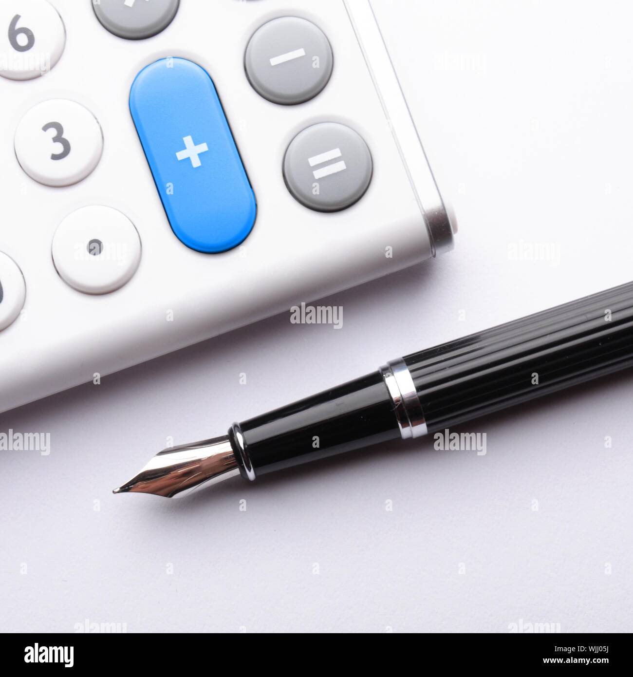 adding up figures concept with modern white calculator in office Stock ...