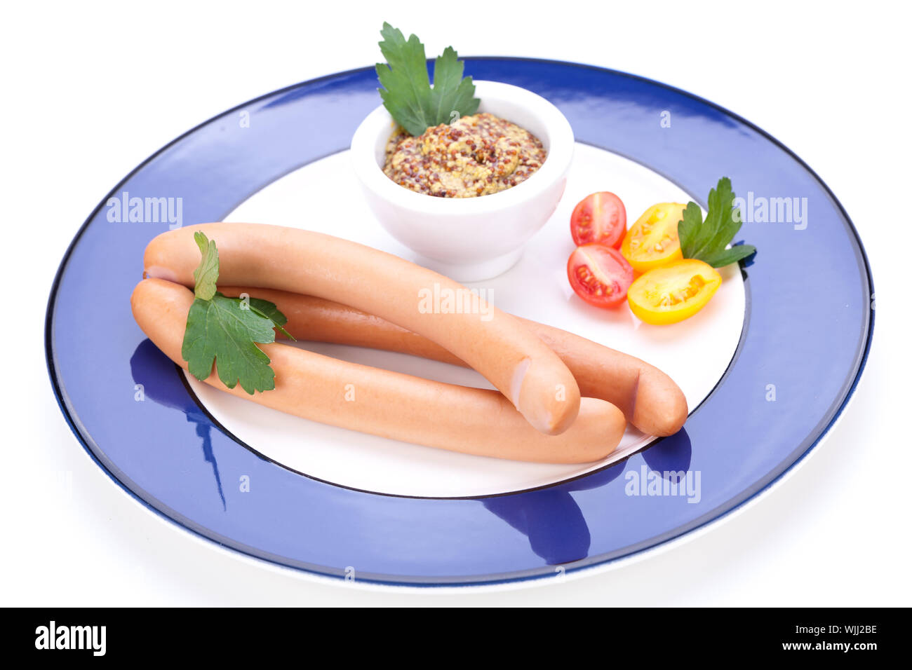 Three cold smoked frankfurters or Wiener sausages served on a plate ...