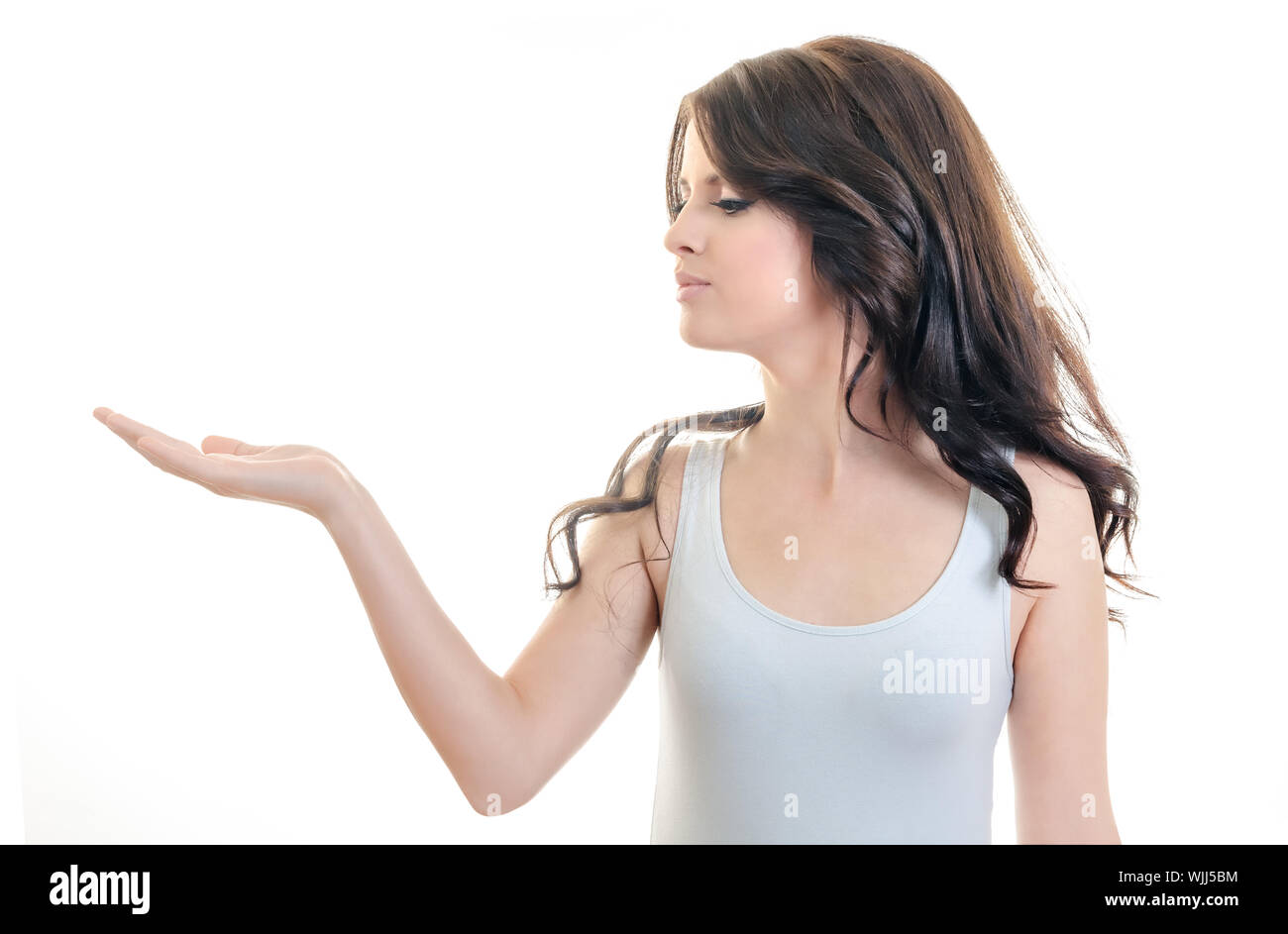 portrait of young beautiful brunette woman posing with empty hand palm ...