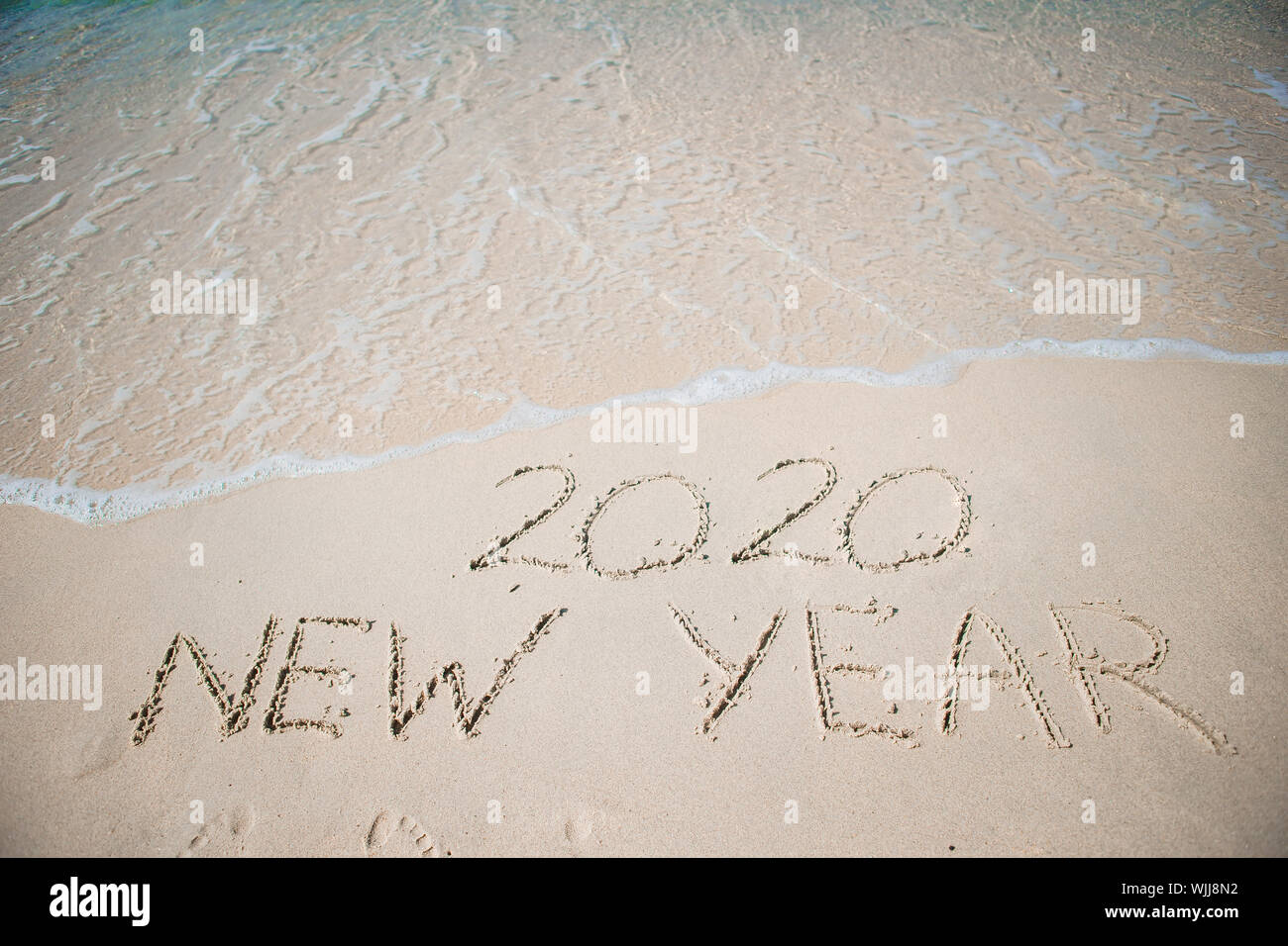 Worlds new year 2020 written in the sand of a beach Stock Photo - Alamy