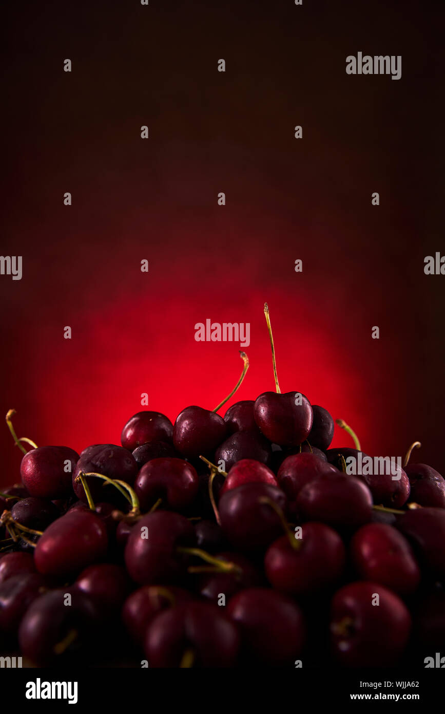 Dark red cherries against a gradient red background Stock Photo - Alamy