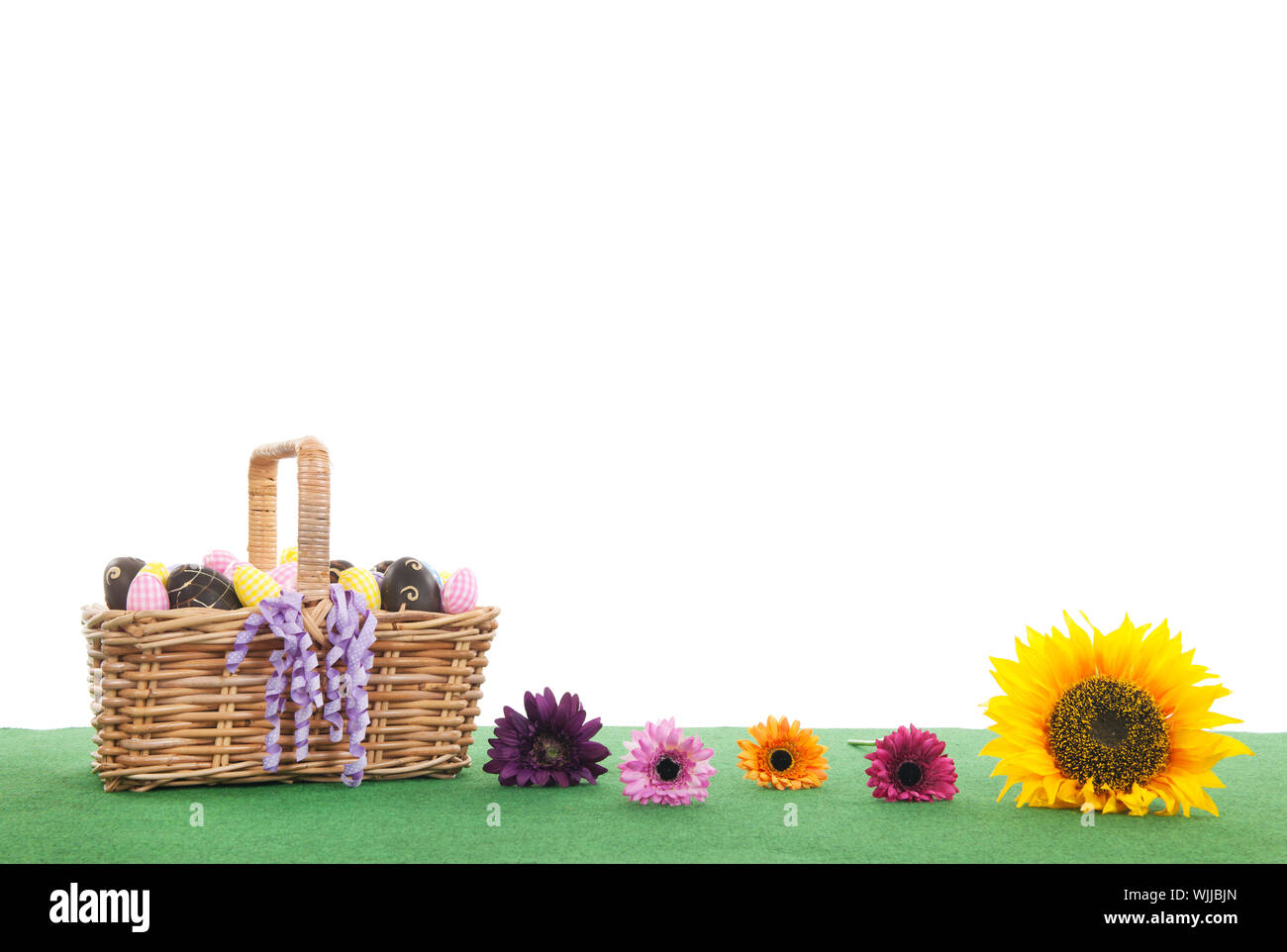 colorful flowers and full basket with easter eggs on green grass Stock ...