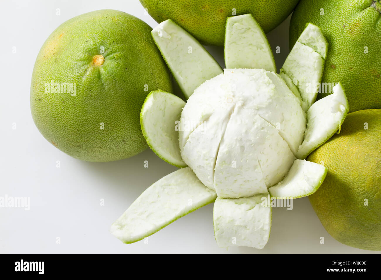 Peeled pomelo with pompelmous on white background Stock Photo - Alamy