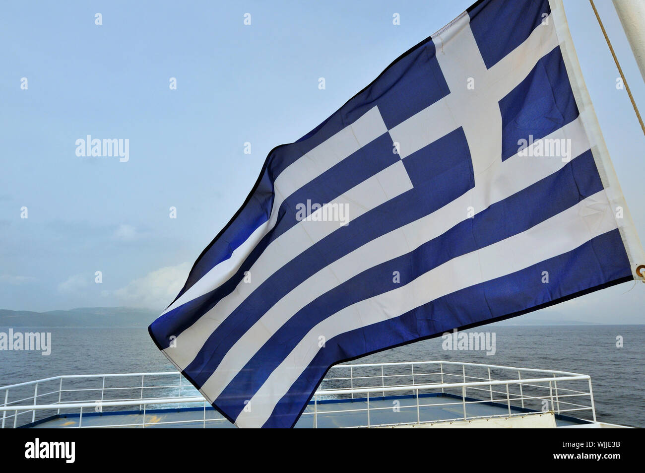 Behind the Greek boat with flag at sea Stock Photo - Alamy