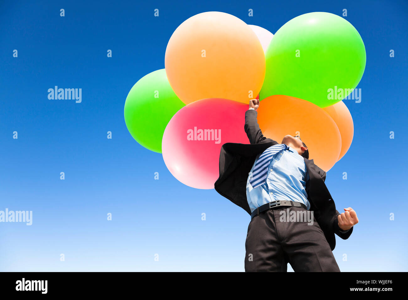 businessman holding balloons and flying up Stock Photo - Alamy
