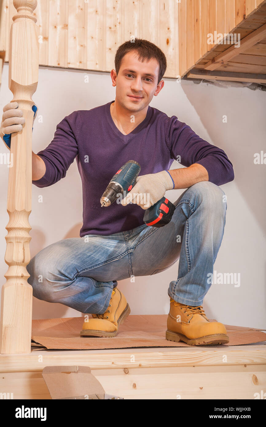 a young carpenter sitting and holding cordless drill Stock Photo - Alamy