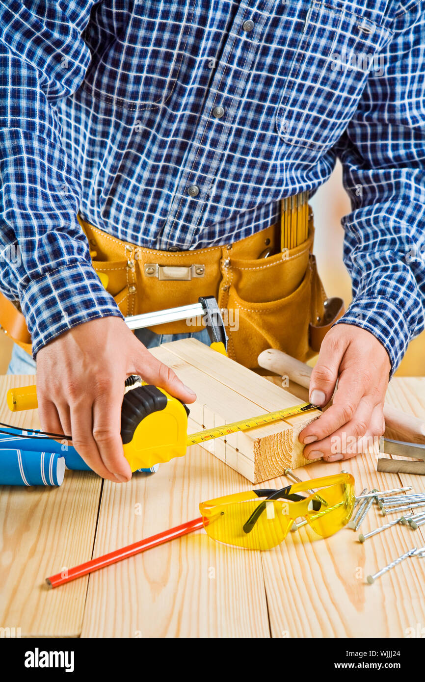 work of carpenter. measuring with roulette Stock Photo - Alamy