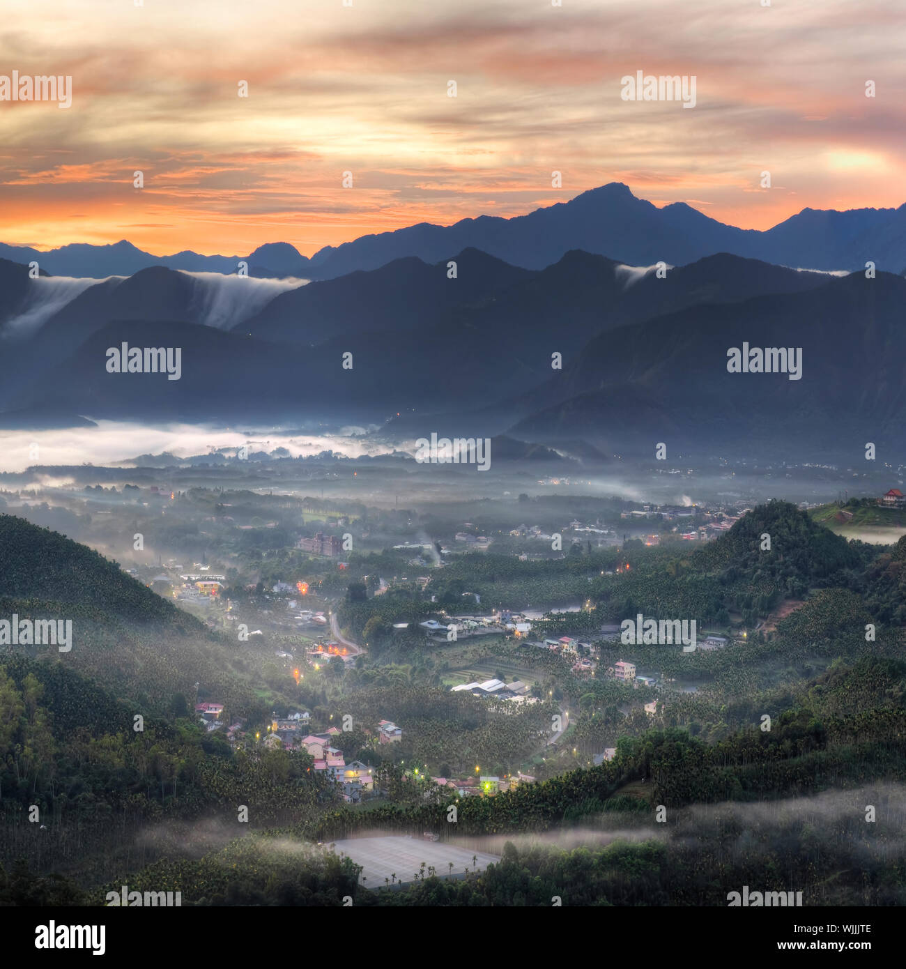 Rural scenery with forest and fog in morning under dramatic sunrise ...