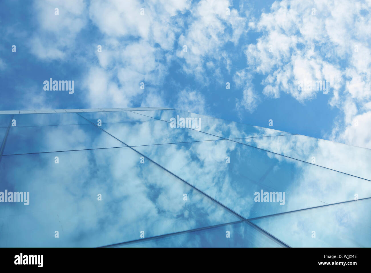 Clouds and blue sky reflection in glass skyscraper Stock Photo - Alamy