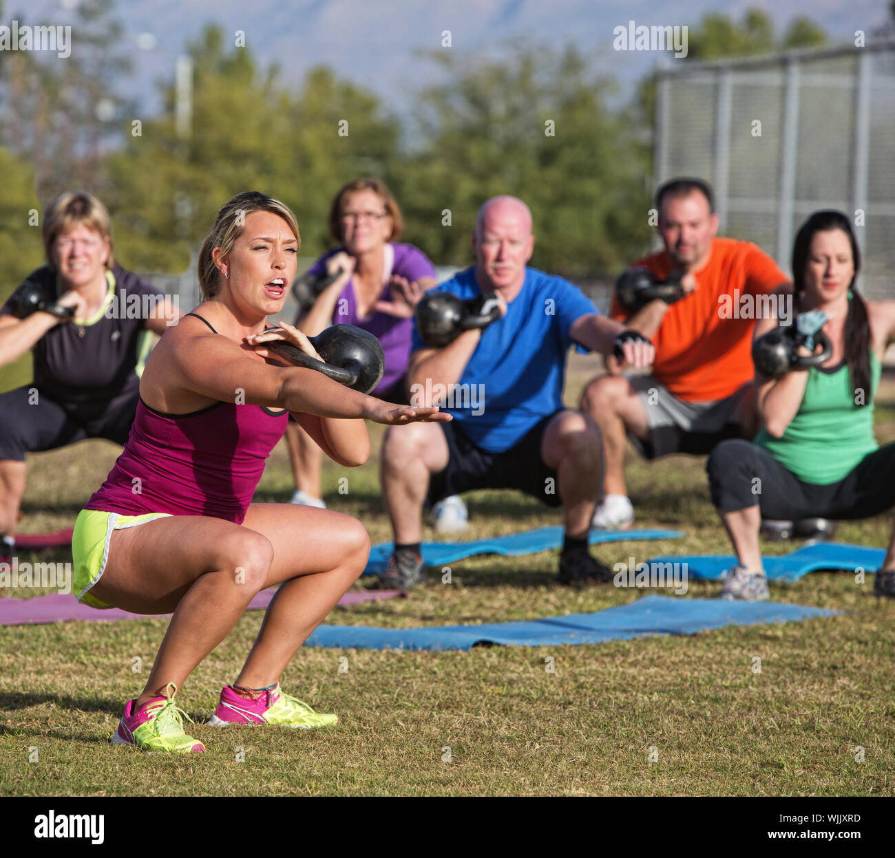Boot camp fitness trainer yelling during squat exercises Stock Photo ...