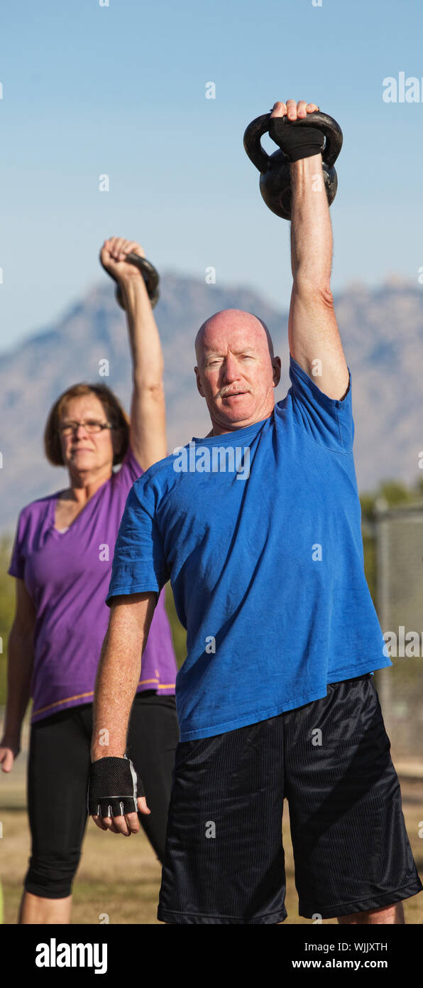 Fit pair of middle aged people exercising with weights Stock Photo - Alamy