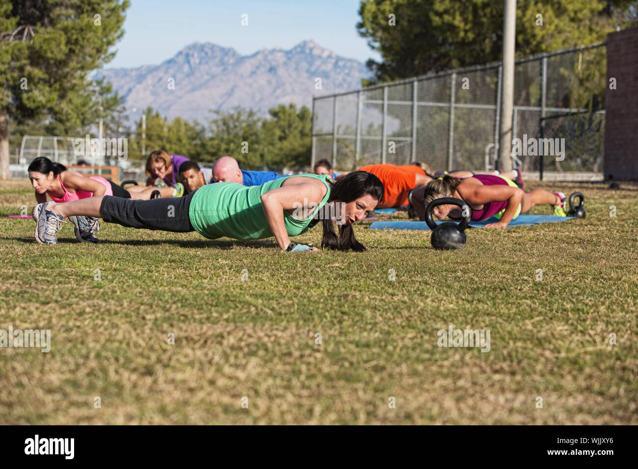 Boot camp fitness group doing push up exercises outdoors Stock Photo ...