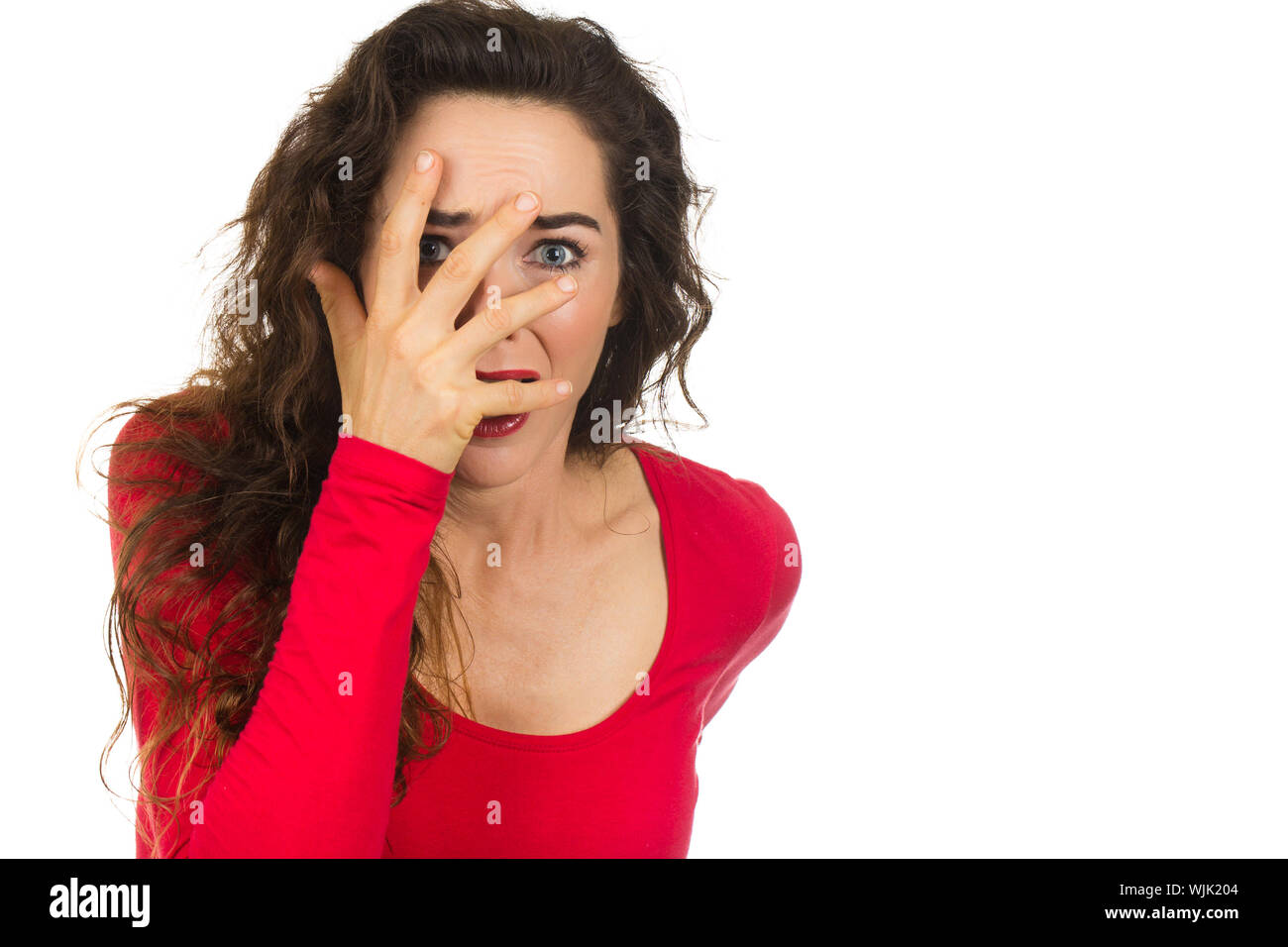 A scared and terrified woman covering her face in fright. Isolated on ...