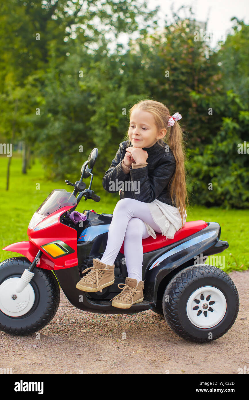 Adorable little girl having fun on her toy motorcycle Stock Photo - Alamy