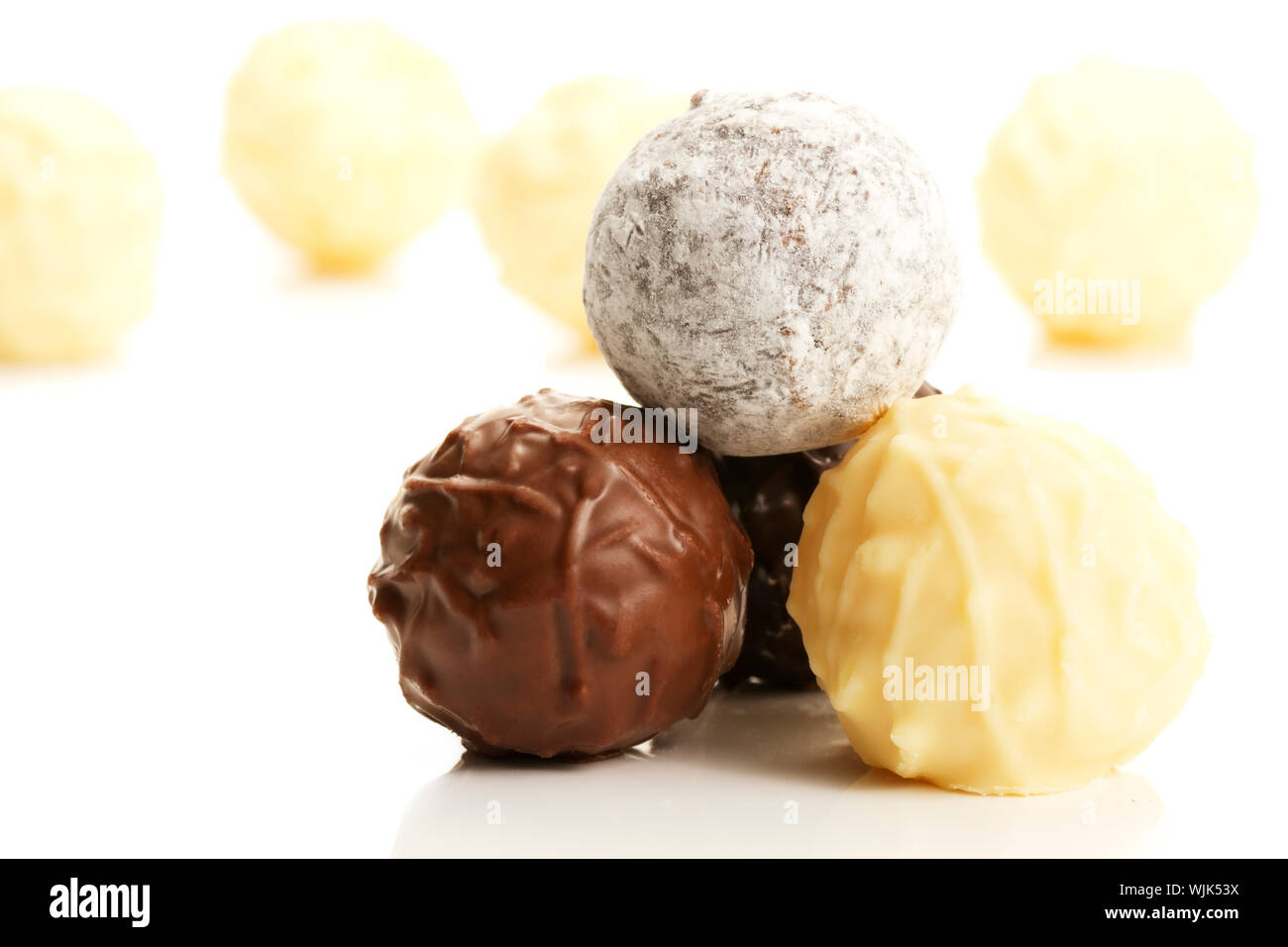 stack of different truffle pralines in front of yellow truffles on ...